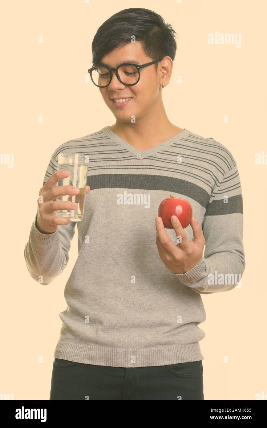 Studio shot of young handsome Filipino man isolated against white ...