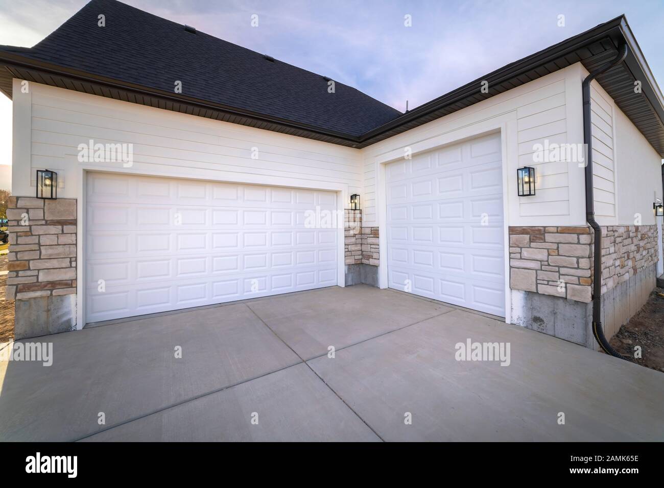 Two garage doors sharing a paved forecourt Stock Photo - Alamy