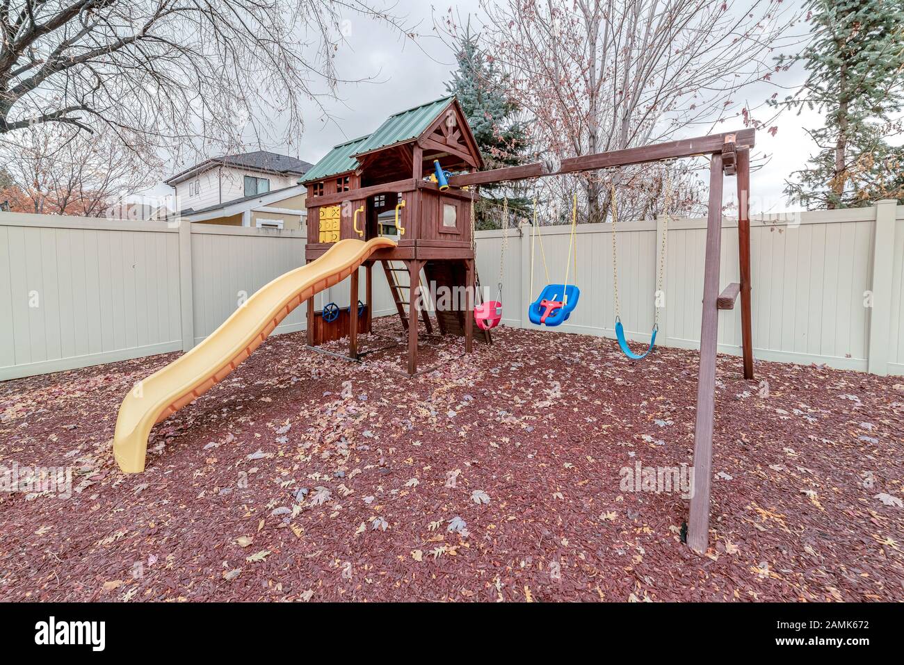 Kids playground with slide and wooden elevated hut Stock Photo - Alamy