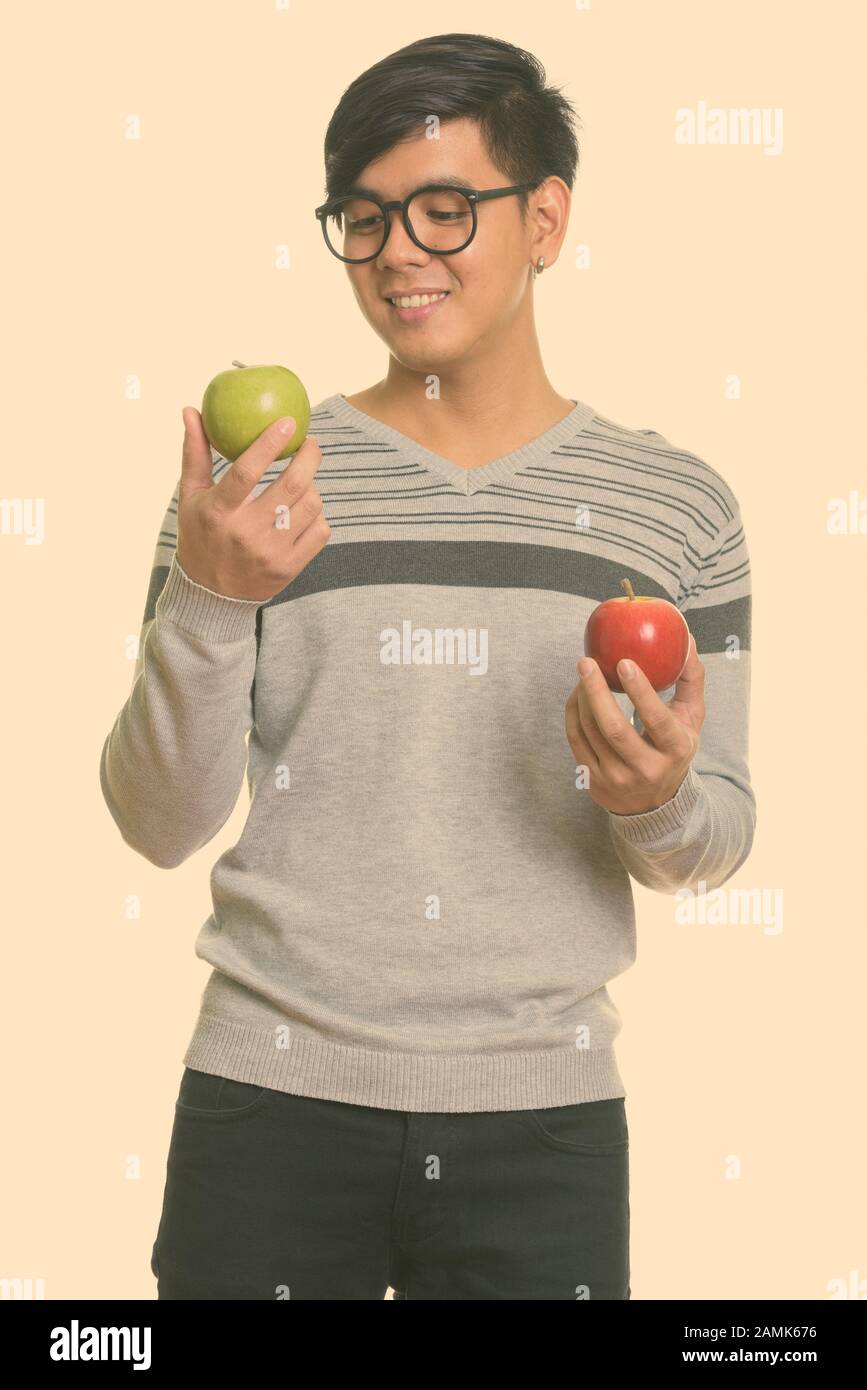 Studio shot of young handsome Filipino man isolated against white ...