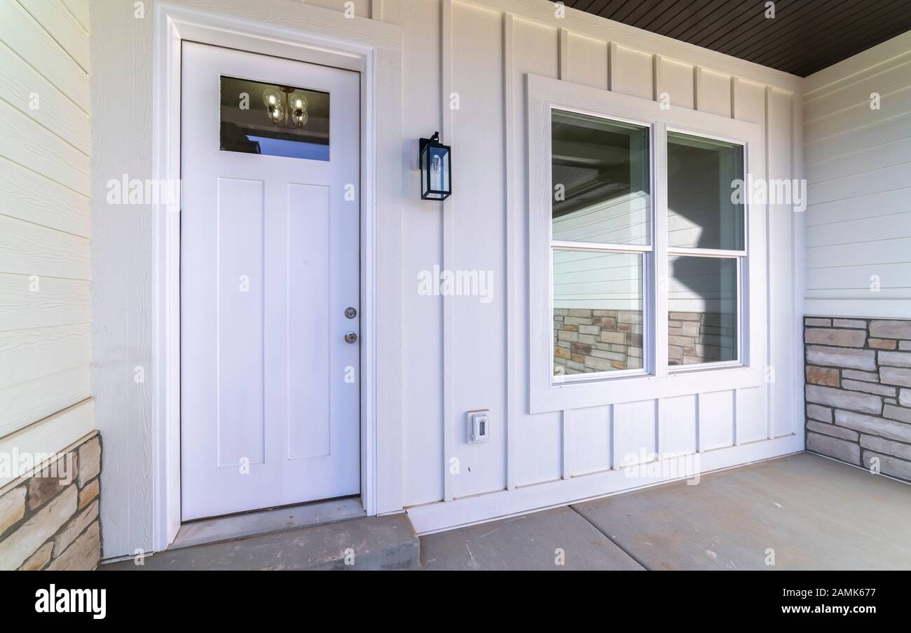 Large square window alongside a white door Stock Photo - Alamy