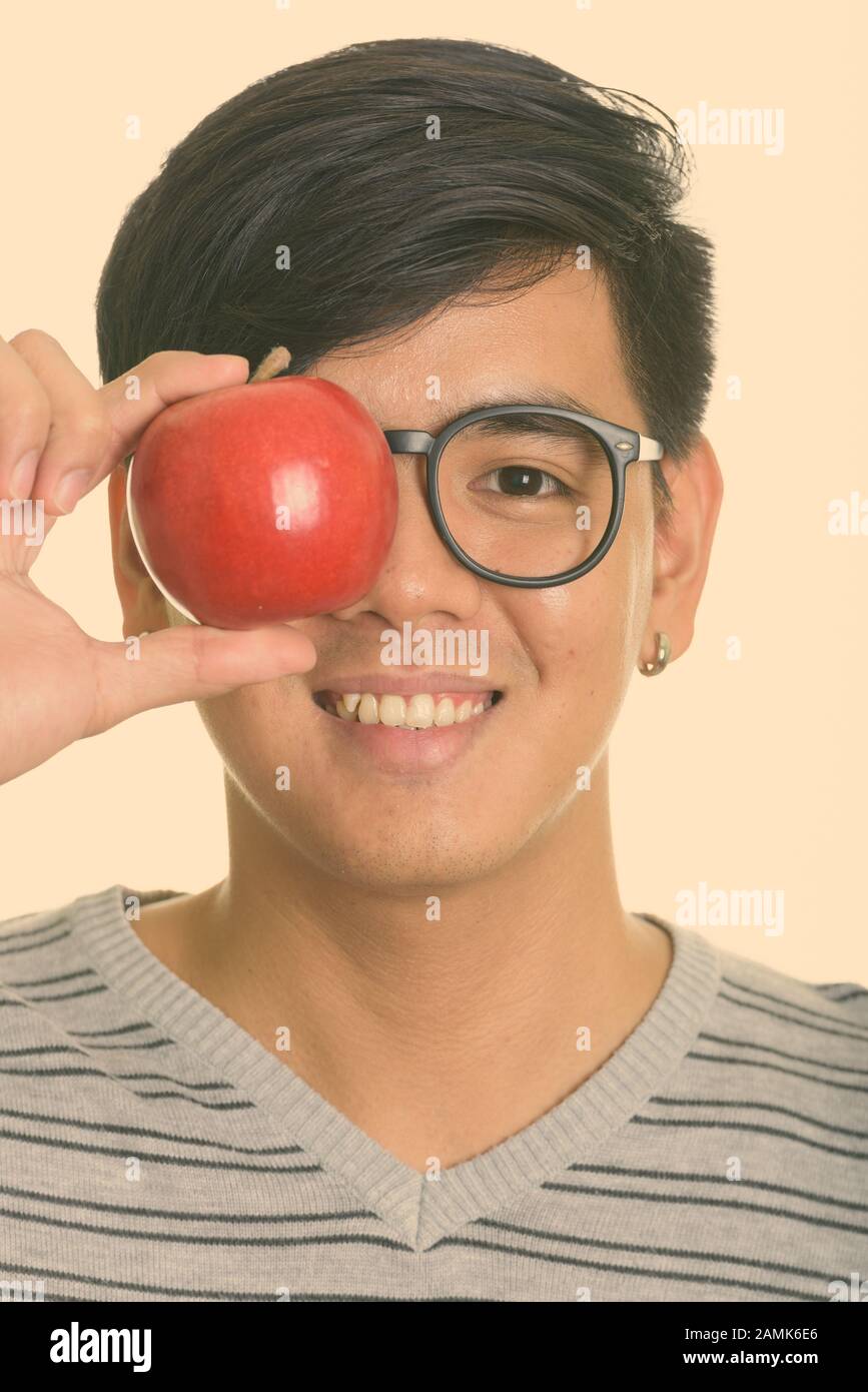Studio shot of young handsome Filipino man isolated against white ...