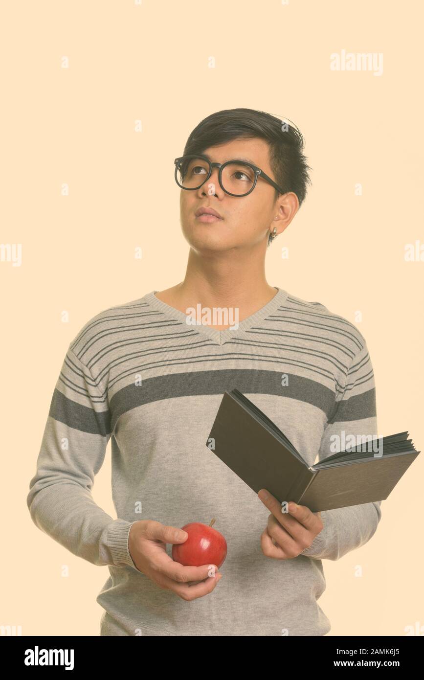 Studio shot of young handsome Filipino man isolated against white ...