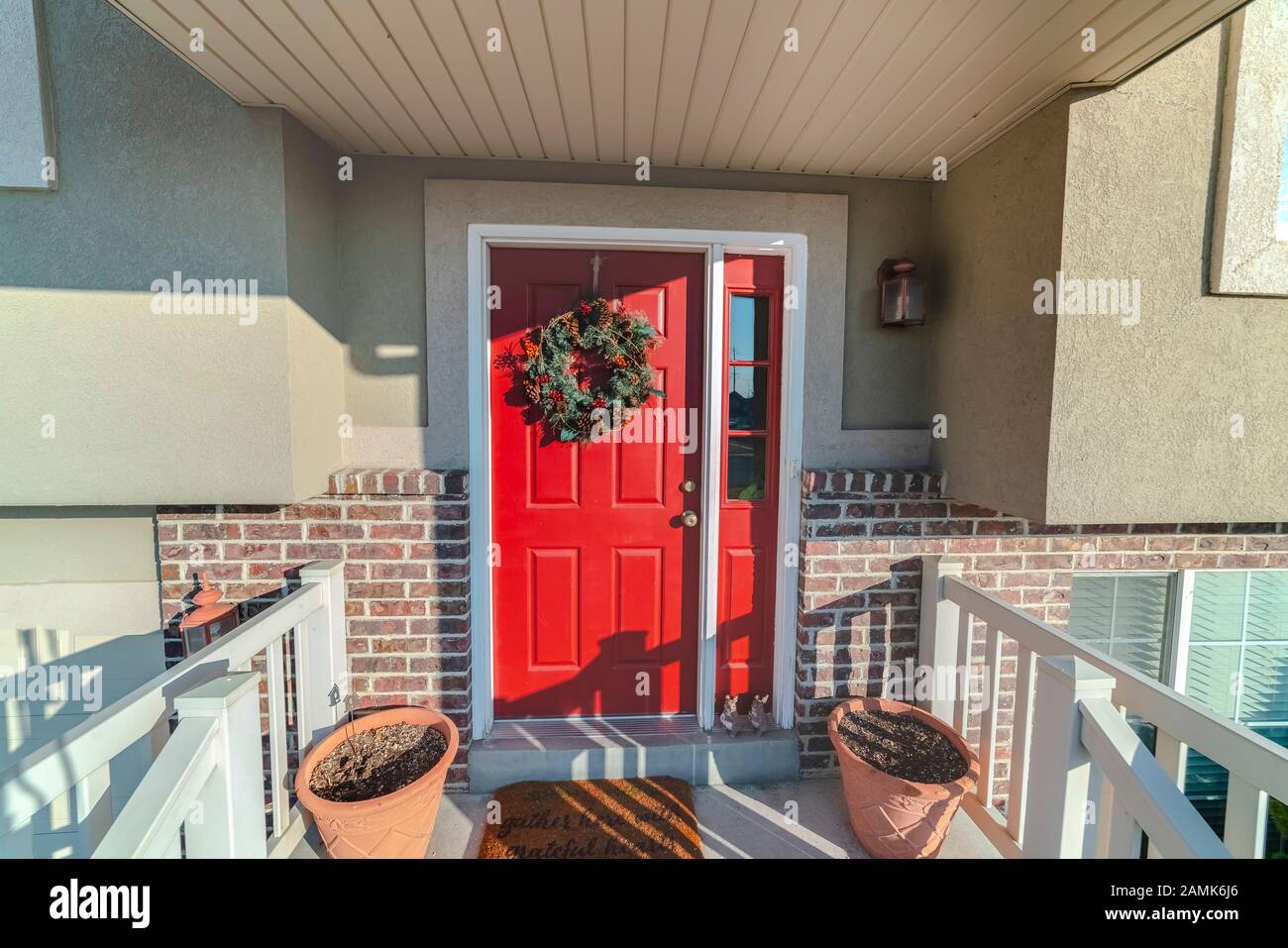 Bright red entrance door with wreath day light Stock Photo - Alamy