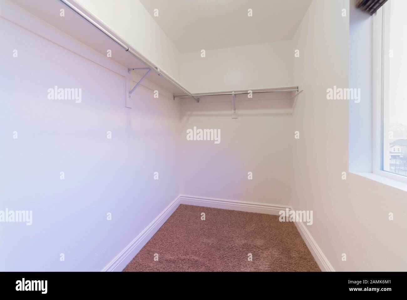 Interior of empty walk-in wardrobe with rails Stock Photo - Alamy