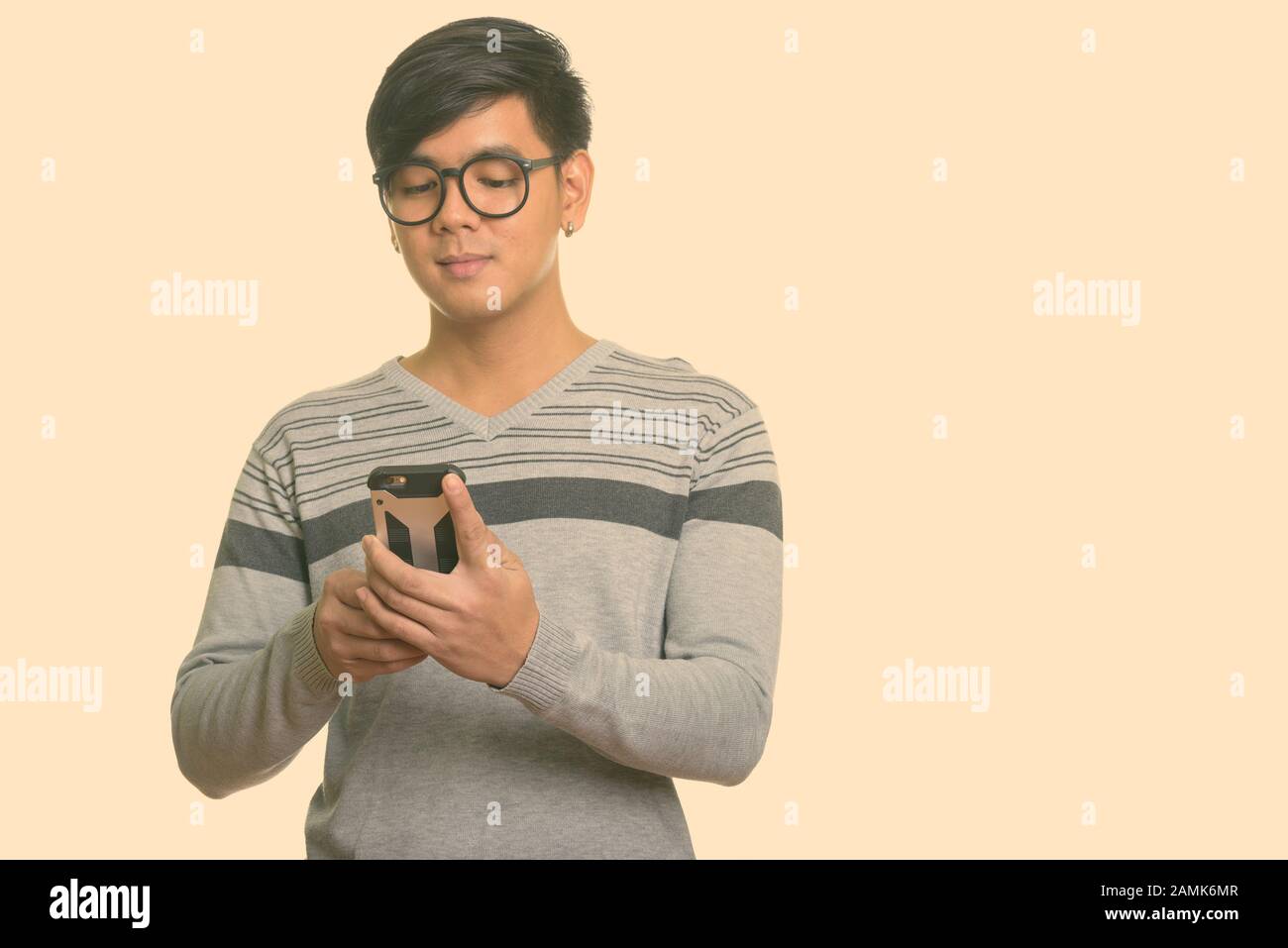 Studio shot of young handsome Filipino man isolated against white ...