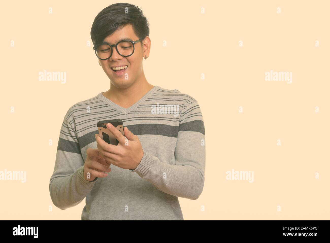 Studio shot of young handsome Filipino man isolated against white ...