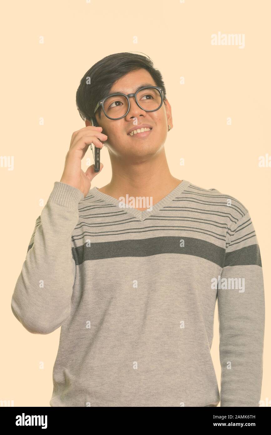 Studio shot of young handsome Filipino man isolated against white ...
