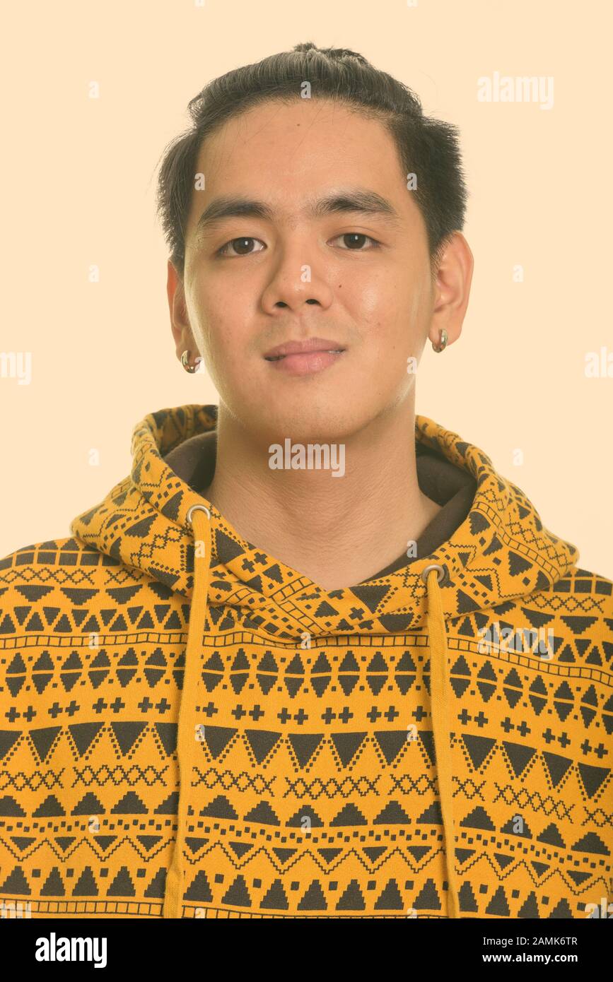 Studio shot of young handsome Filipino man isolated against white ...