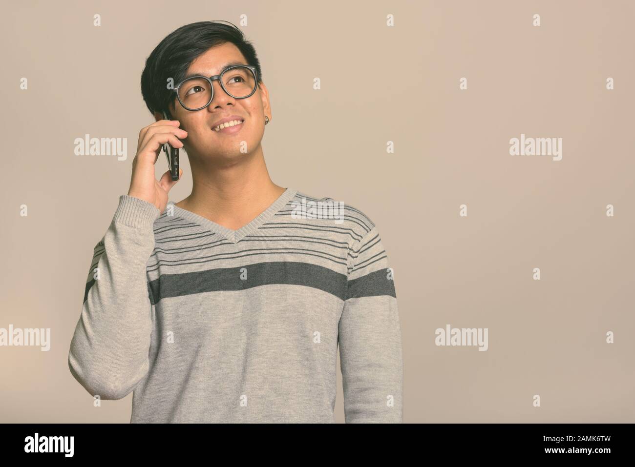 Studio shot of young handsome Filipino man isolated against white ...