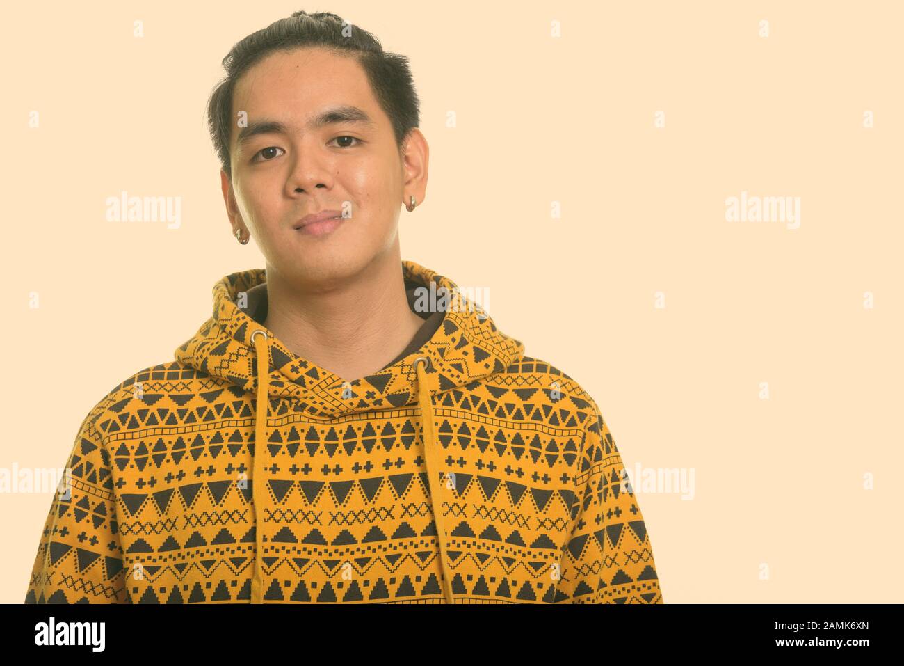 Studio shot of young handsome Filipino man isolated against white ...