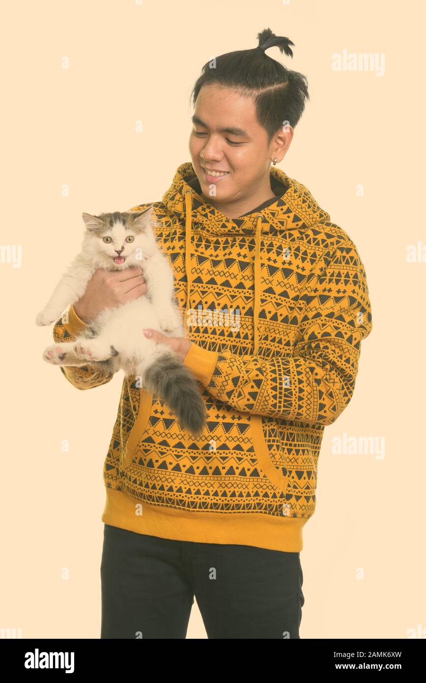 Studio shot of young handsome Filipino man isolated against white ...