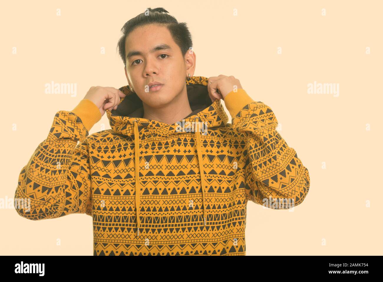 Studio shot of young handsome Filipino man isolated against white ...