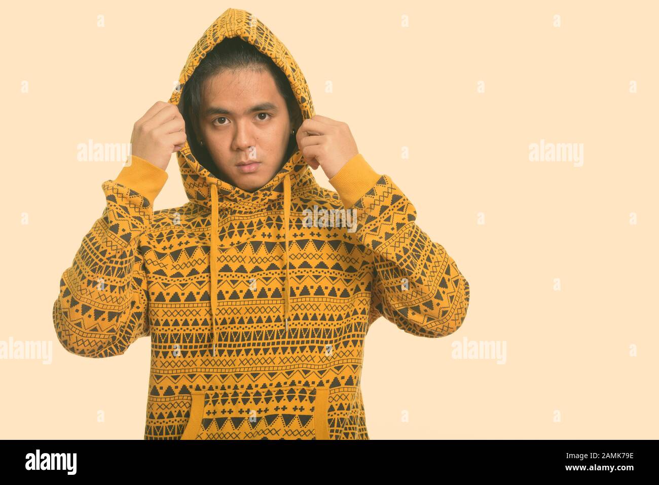 Studio shot of young handsome Filipino man isolated against white ...