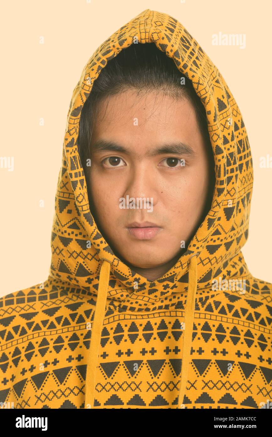 Studio shot of young handsome Filipino man isolated against white ...