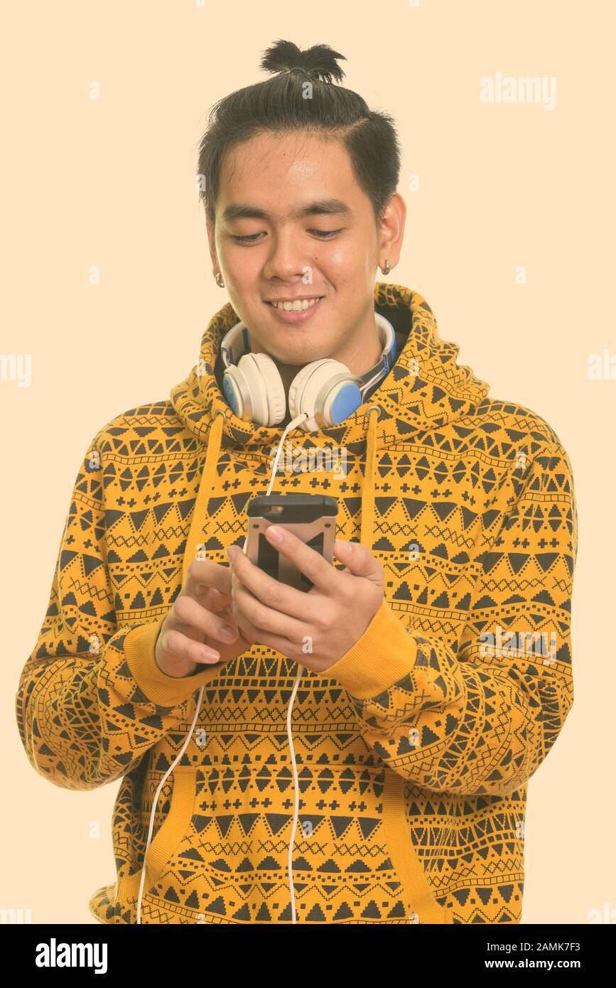 Studio shot of young handsome Filipino man isolated against white ...