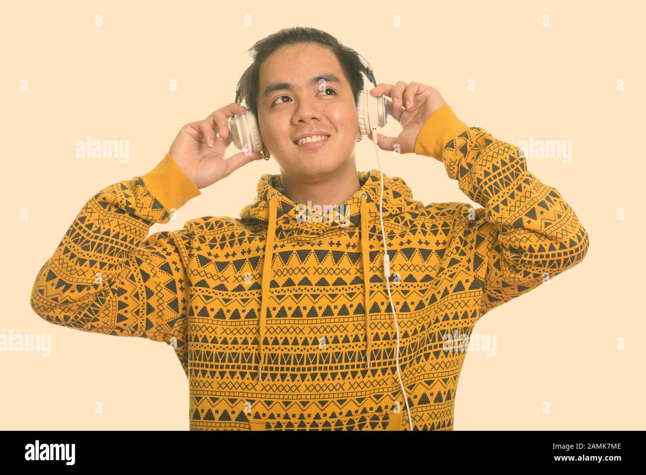 Studio shot of young handsome Filipino man isolated against white ...