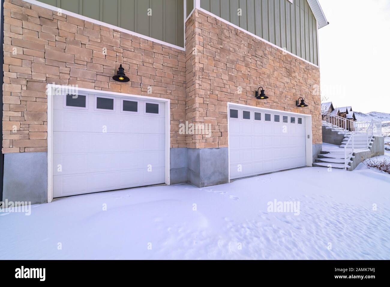 Snow covered forecourt with double garage doors Stock Photo - Alamy