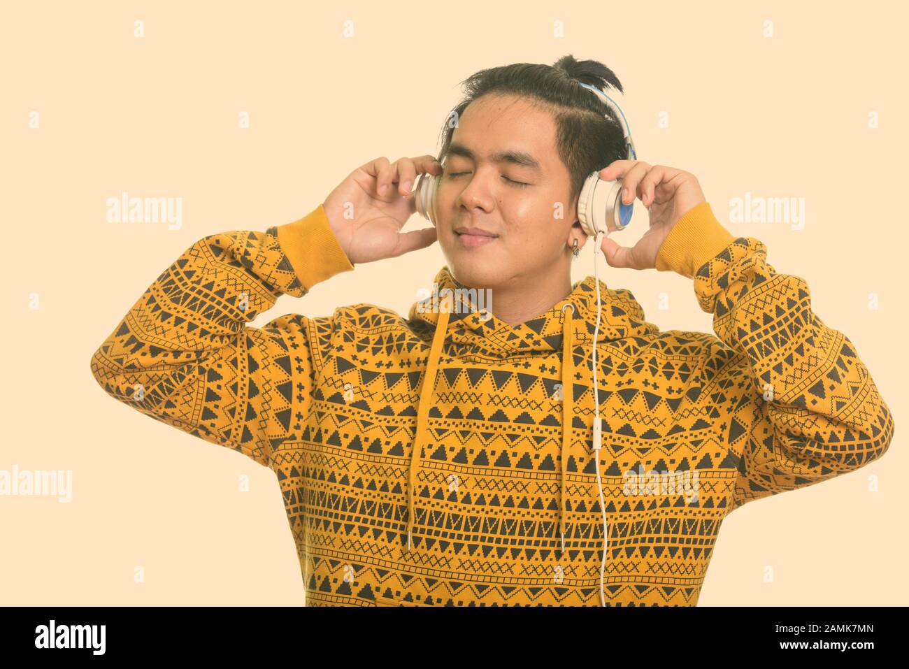 Studio shot of young handsome Filipino man isolated against white ...
