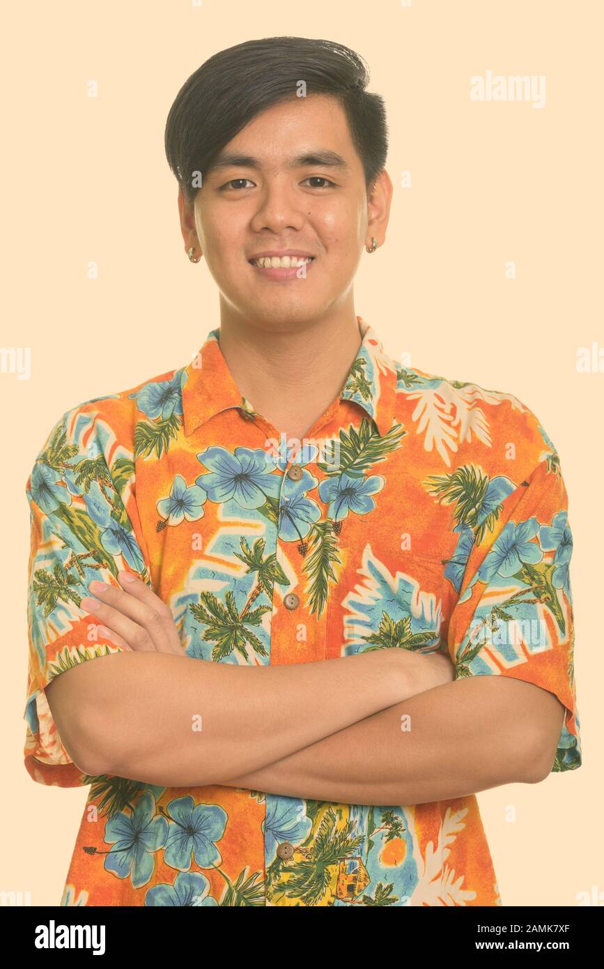 Studio shot of young handsome Filipino man isolated against white ...