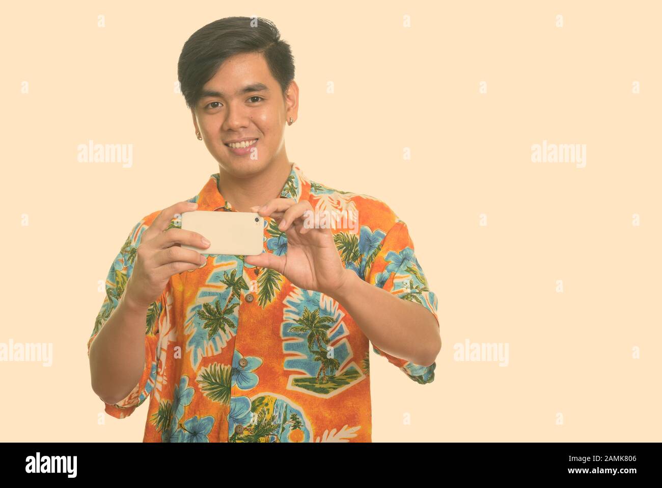 Studio shot of young handsome Filipino man isolated against white ...