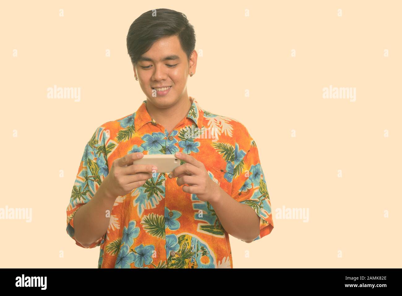 Studio shot of young handsome Filipino man isolated against white ...