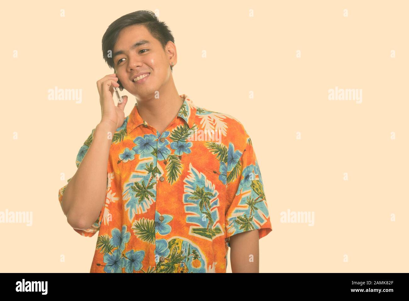 Studio shot of young handsome Filipino man isolated against white ...
