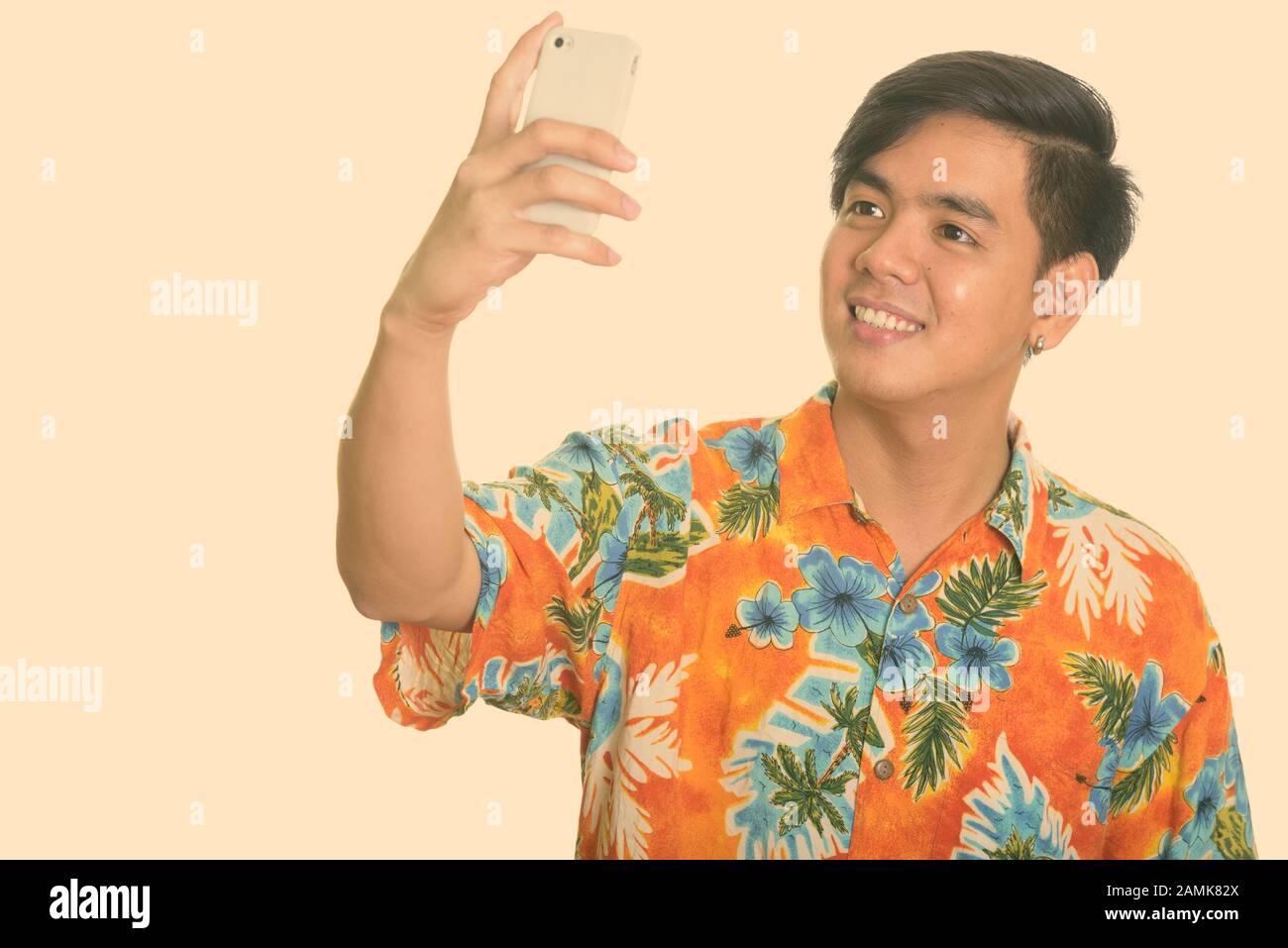 Studio shot of young handsome Filipino man isolated against white ...