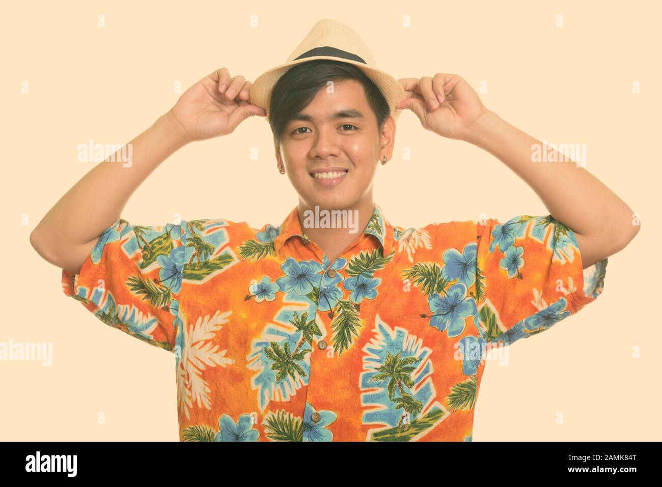 Studio shot of young handsome Filipino man isolated against white ...