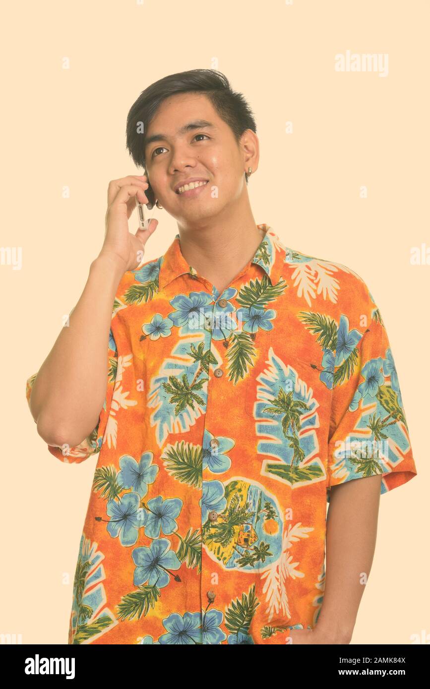 Studio shot of young handsome Filipino man isolated against white ...