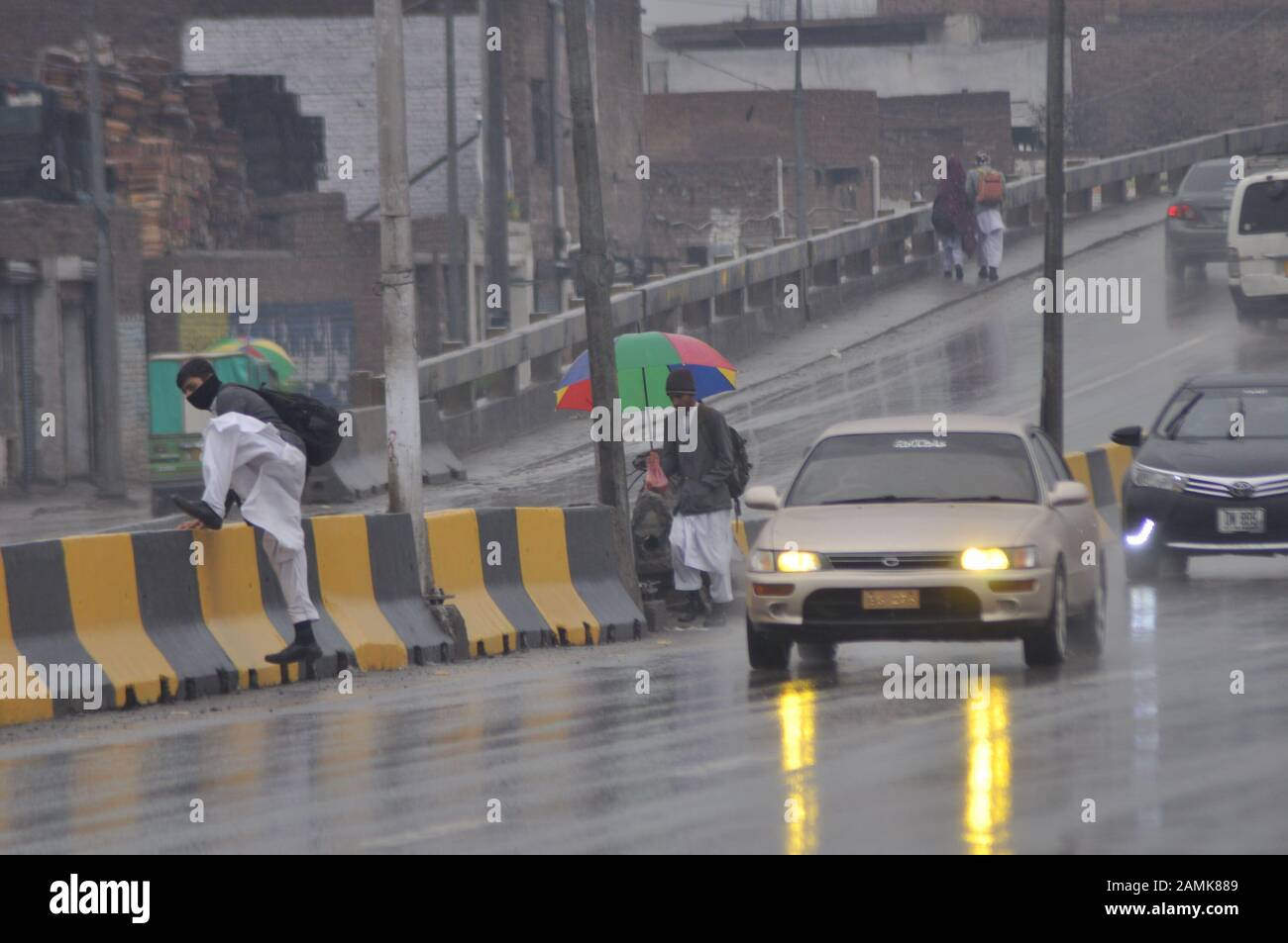 Peshawar, Pakistan. 13th Jan, 2020. A motorcyclist covers with a shawl ...