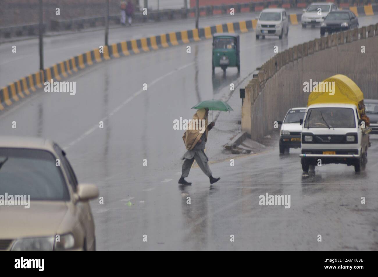 Peshawar, Pakistan. 13th Jan, 2020. A motorcyclist covers with a shawl ...