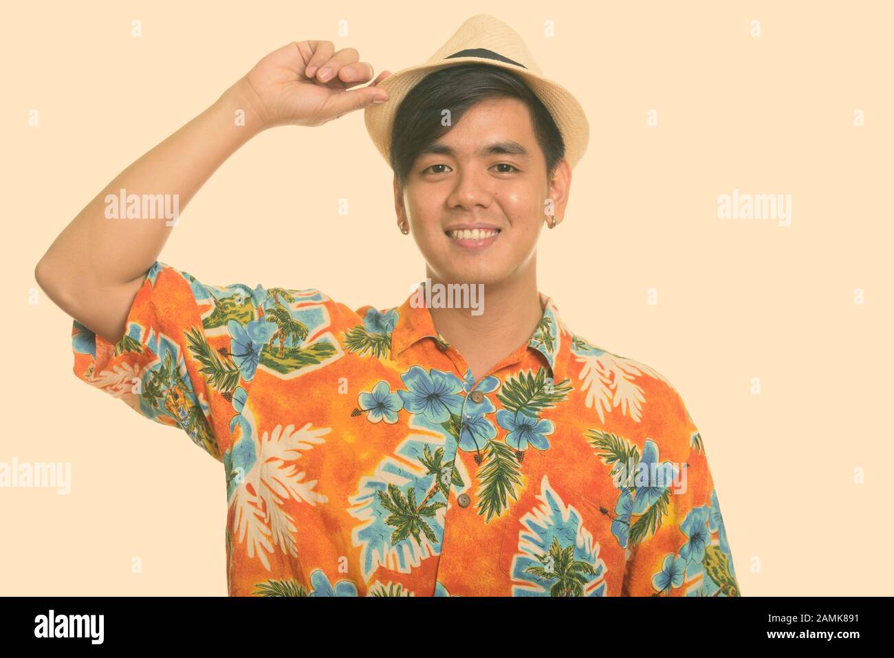 Studio shot of young handsome Filipino man isolated against white ...