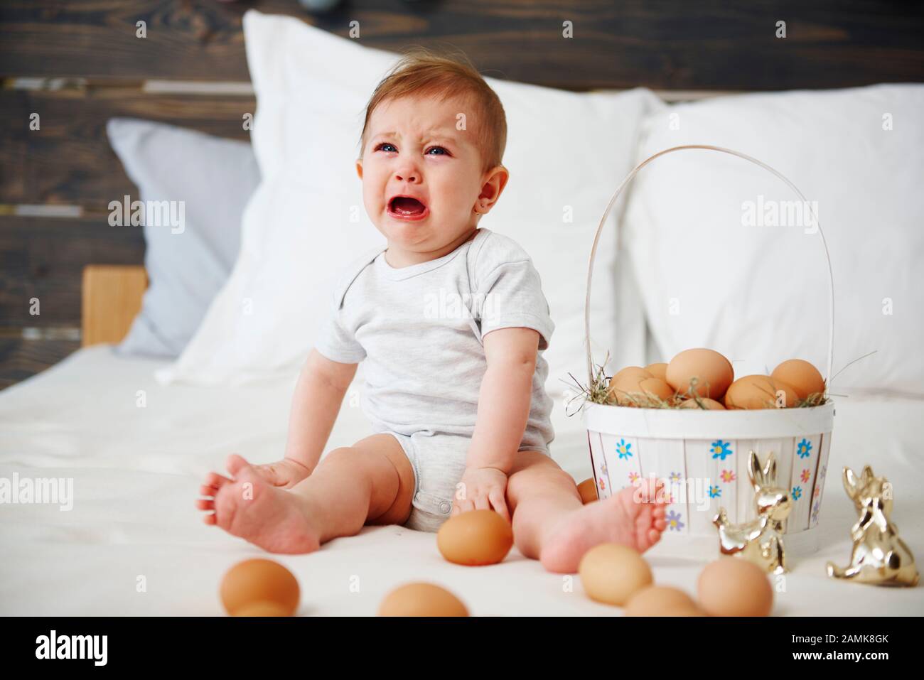 Crying baby celebrating Easter morning in bed Stock Photo - Alamy