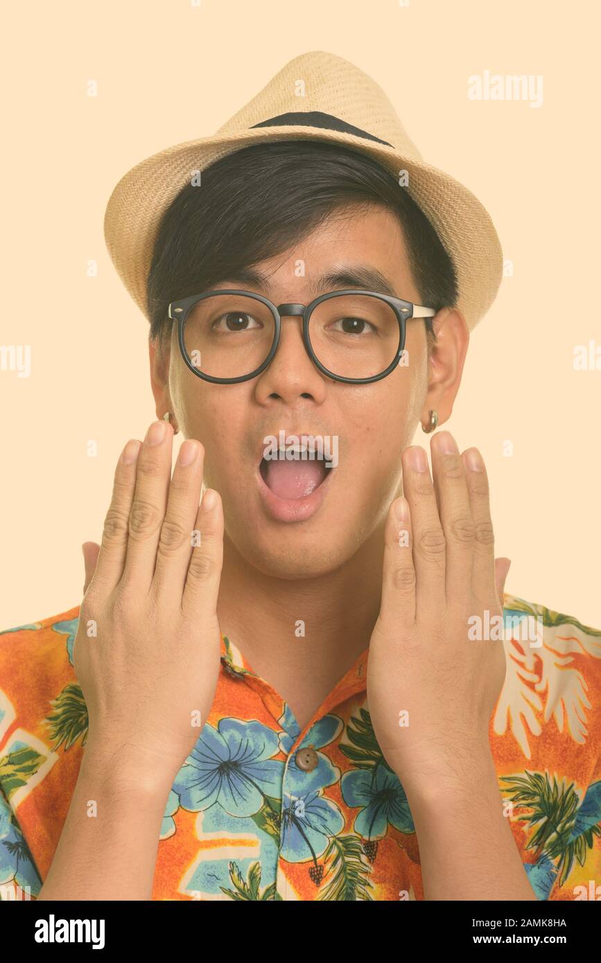 Studio shot of young handsome Filipino man isolated against white ...
