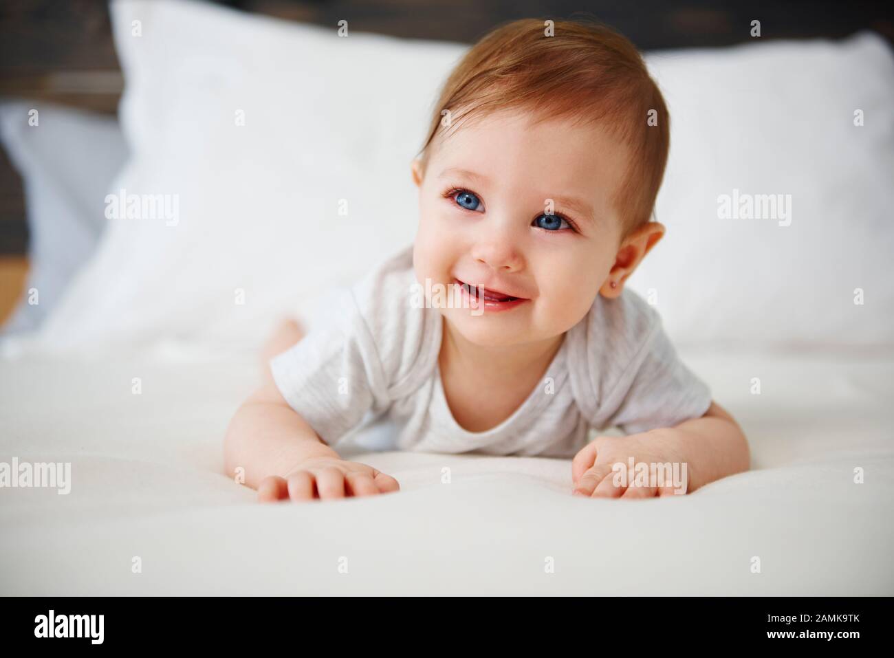 Charming baby lying on the bed Stock Photo - Alamy