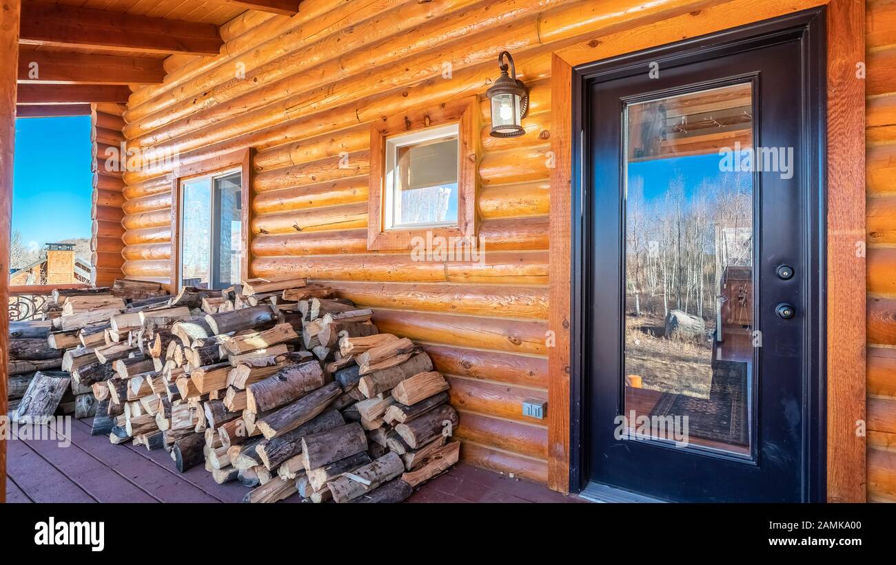 Panorama Log cabin with stacked firewood on the porch Stock Photo - Alamy