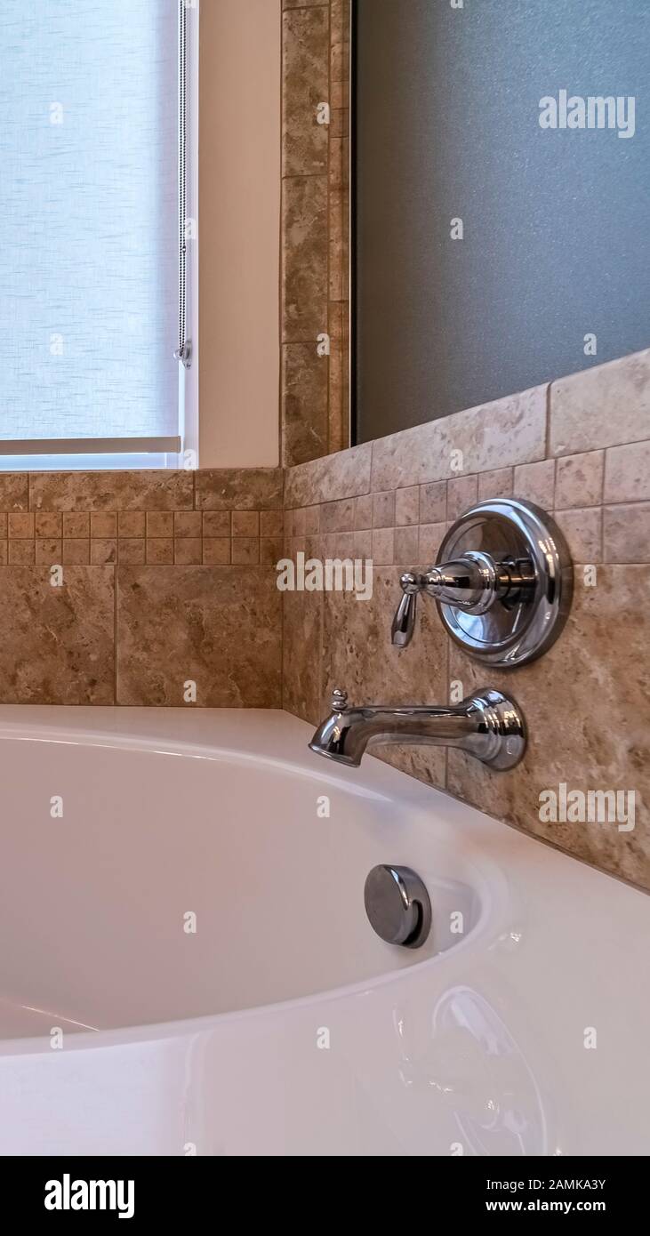 Vertical Small bathtub with mixer tap on wall Stock Photo - Alamy