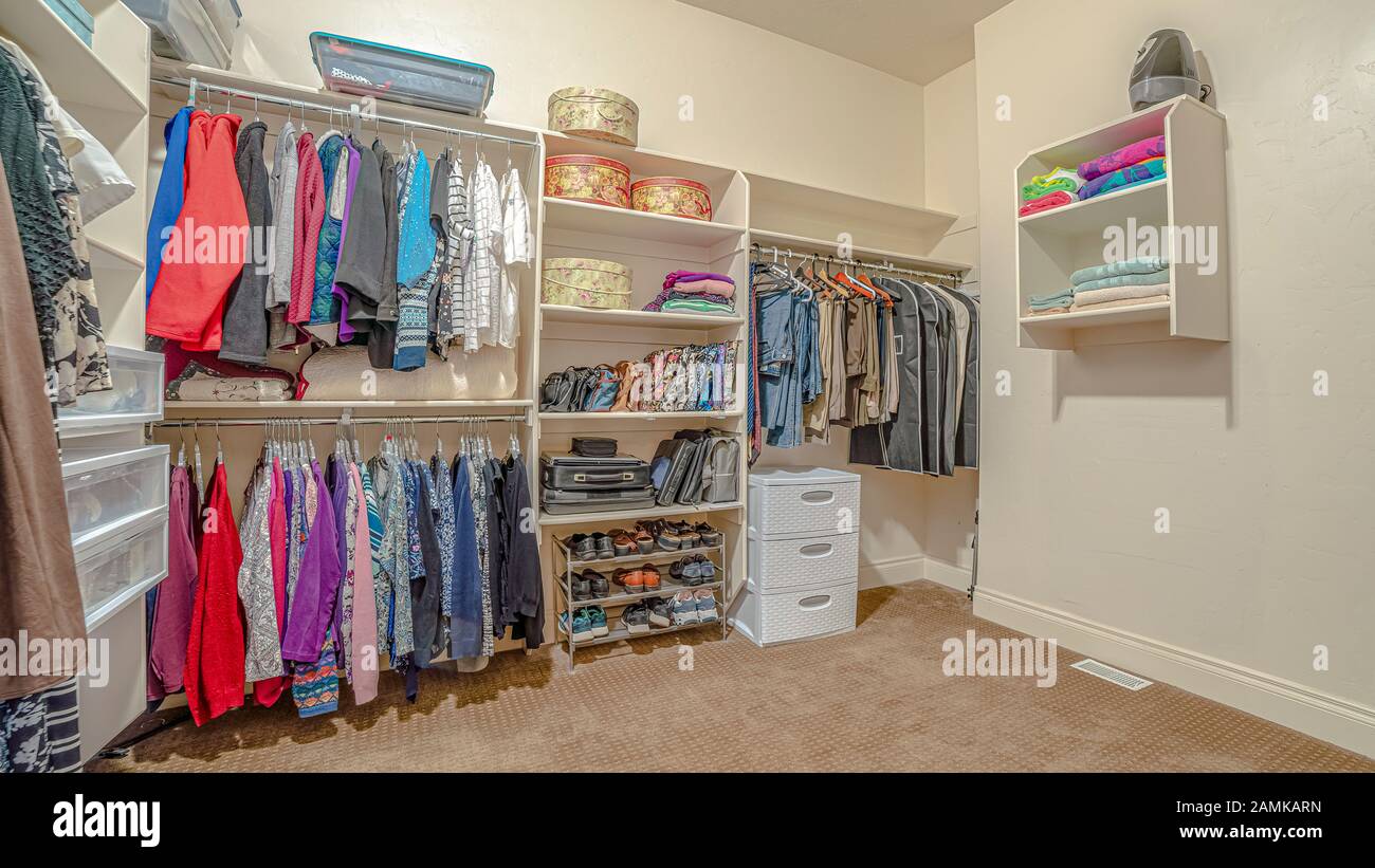 Panorama Colorful clothes hanging in a walk-in wardrobe Stock Photo - Alamy
