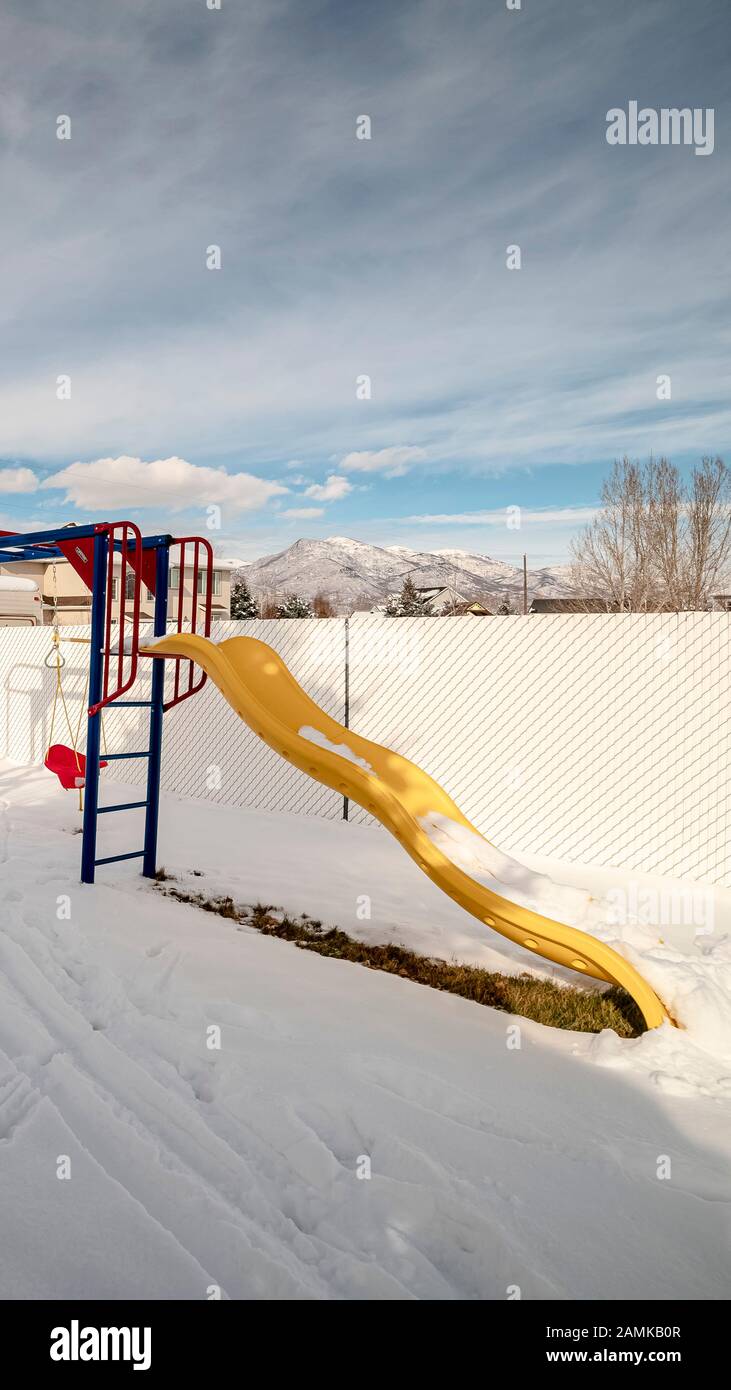 Vertical Kids winter playground with swings and slide Stock Photo - Alamy