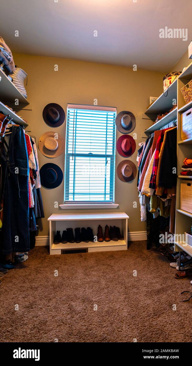 Vertical Neat walk-in closet full of clothes day light Stock Photo - Alamy