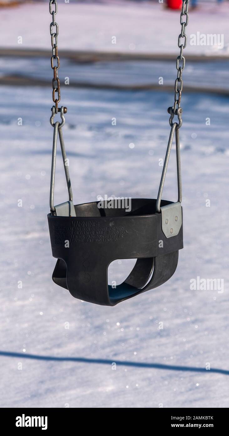 Vertical Kids swing in a winter playground day light Stock Photo - Alamy