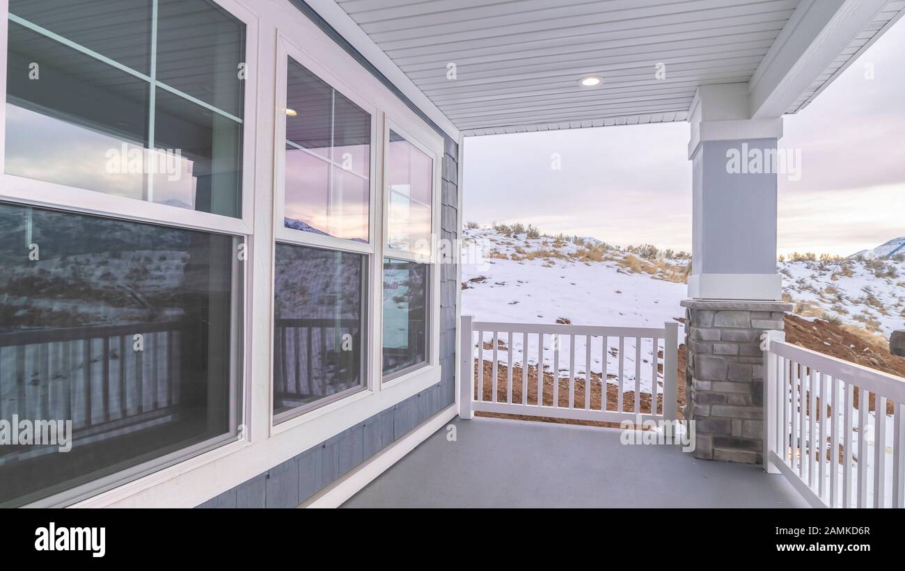 Panorama Long covered patio with large glass windows Stock Photo - Alamy