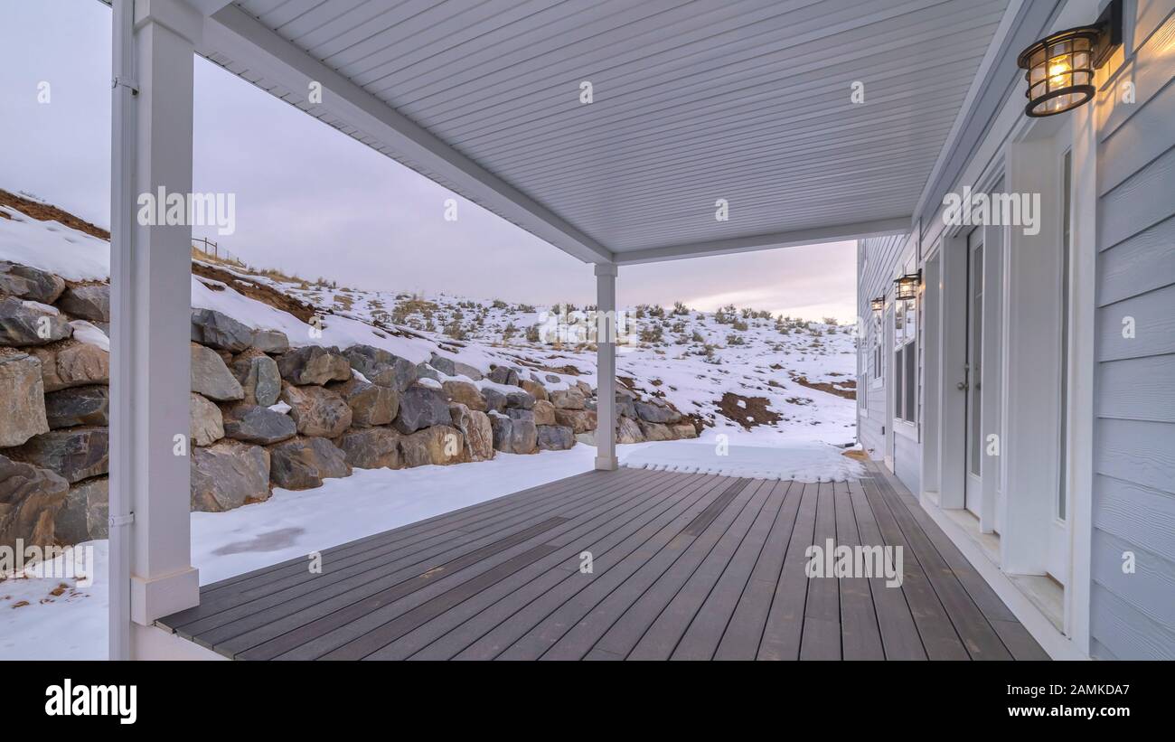 Panorama frame Covered wooden exterior patio facing a stone wall Stock ...