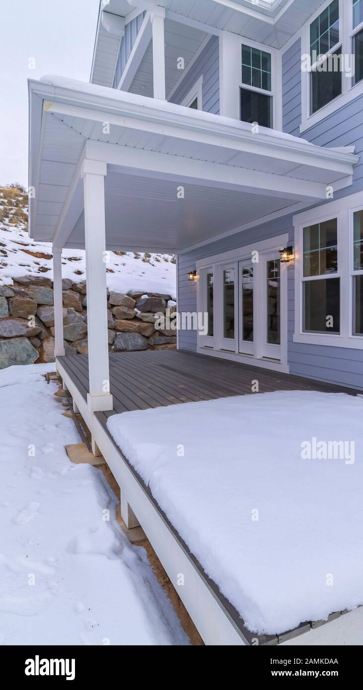Vertical frame Snow covered patio on a grey timber house Stock Photo ...