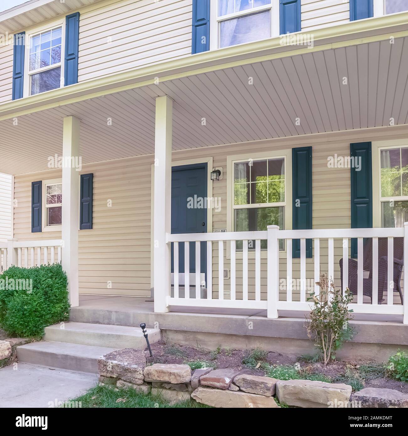 Square white double storey house with large porch Stock Photo - Alamy