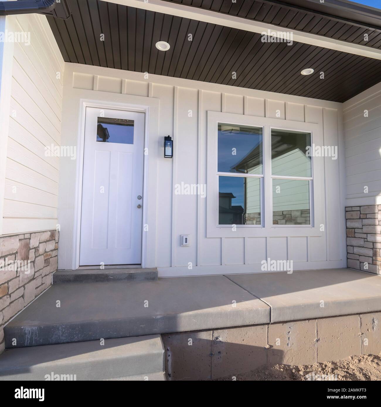 Square frame Entrance door to a white timber clad home Stock Photo - Alamy