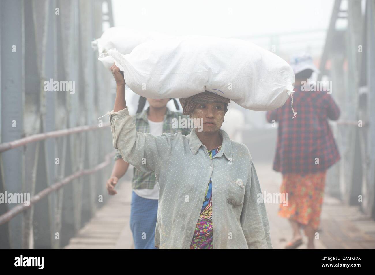 Kyaukpyu, Myanmar. 13th Jan, 2020. Female laborers unload goods from ...