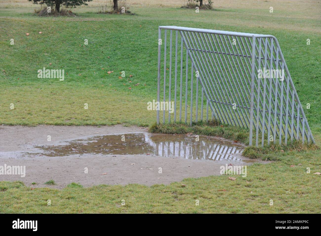 An empty soccer goal with a puddle in front of it on a playground at ...
