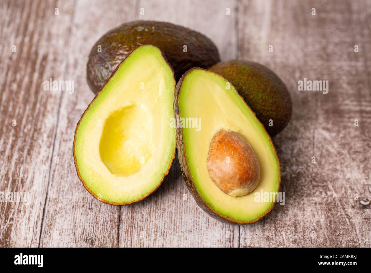 Avocado composition cutted in half on a wooden board Stock Photo - Alamy